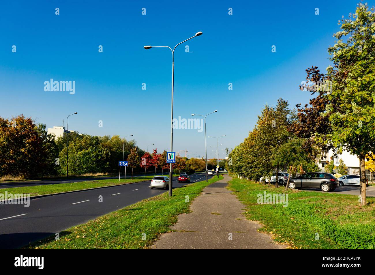 Footpath between green grass next to an asphalt road in Inflancka ...