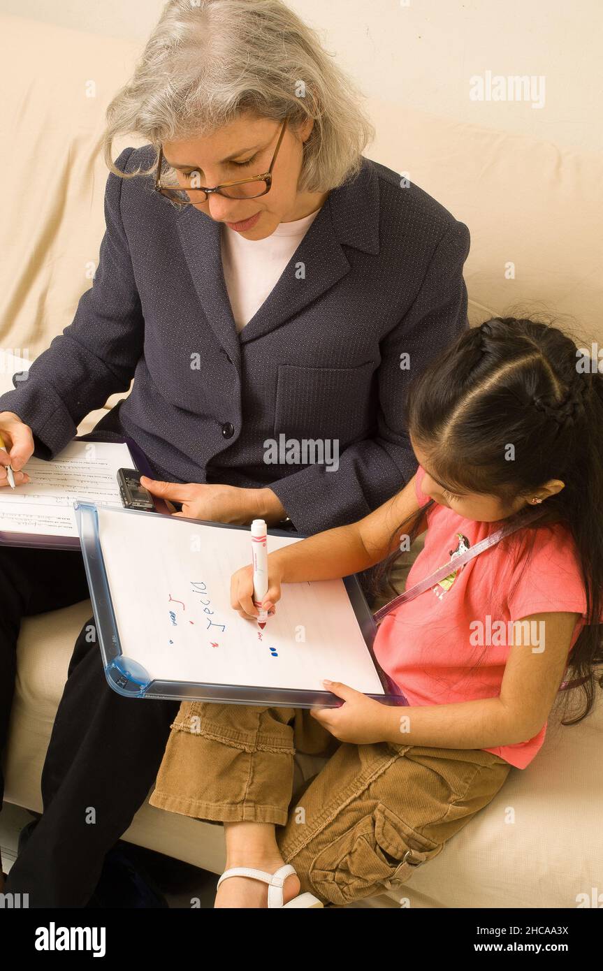 Researcher on home visit to three year old girl interacting with her ...