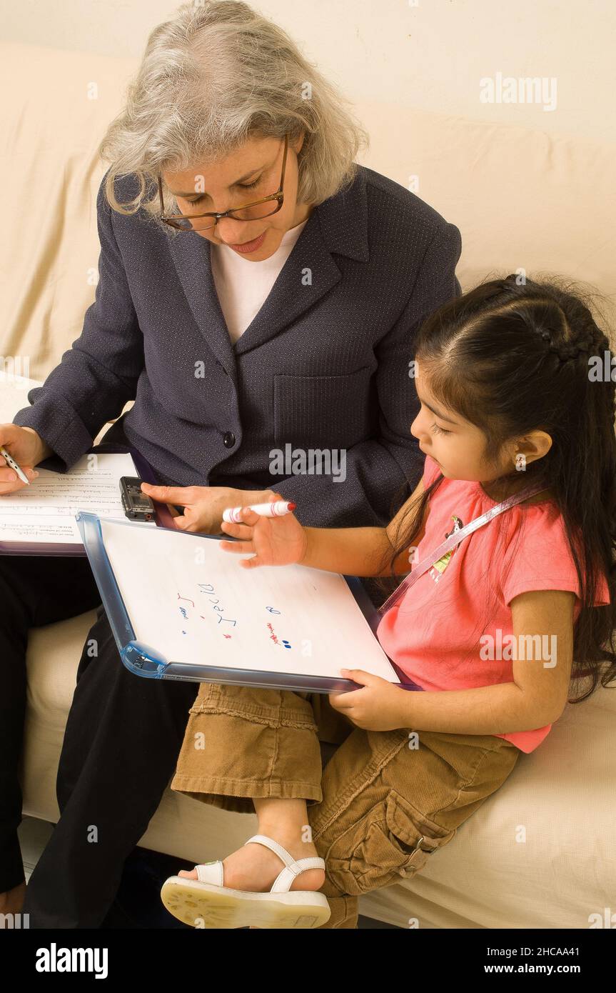 Researcher on home visit to three year old girl interacting with her ...