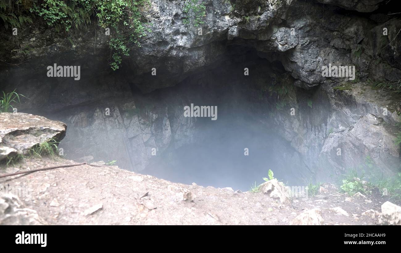 Beautiful natural landscape with a foggy cave surrounded by green ...