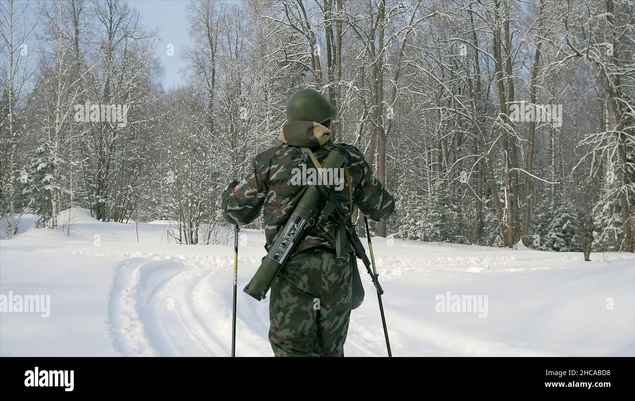Group of soldiers run on skis in the woods with weapons. Clip. Soldiers ...