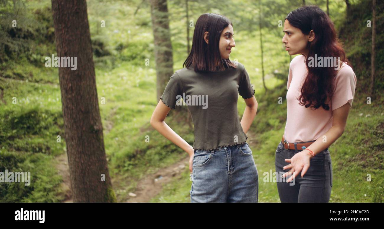 Two Indian female standing in the forest talking to each other with ...