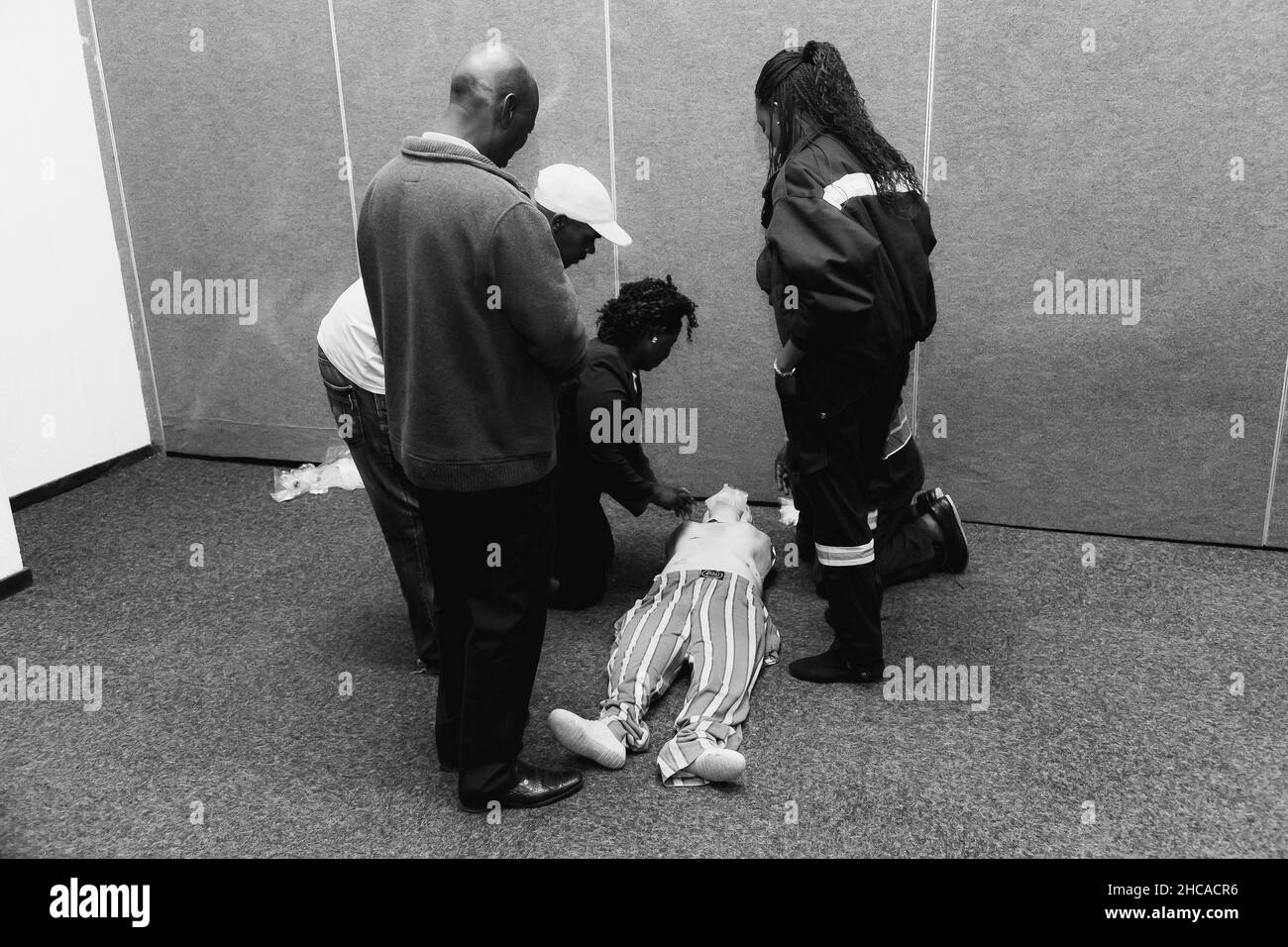 Grayscale of a First Aid CPR training with plastic dummy in ...