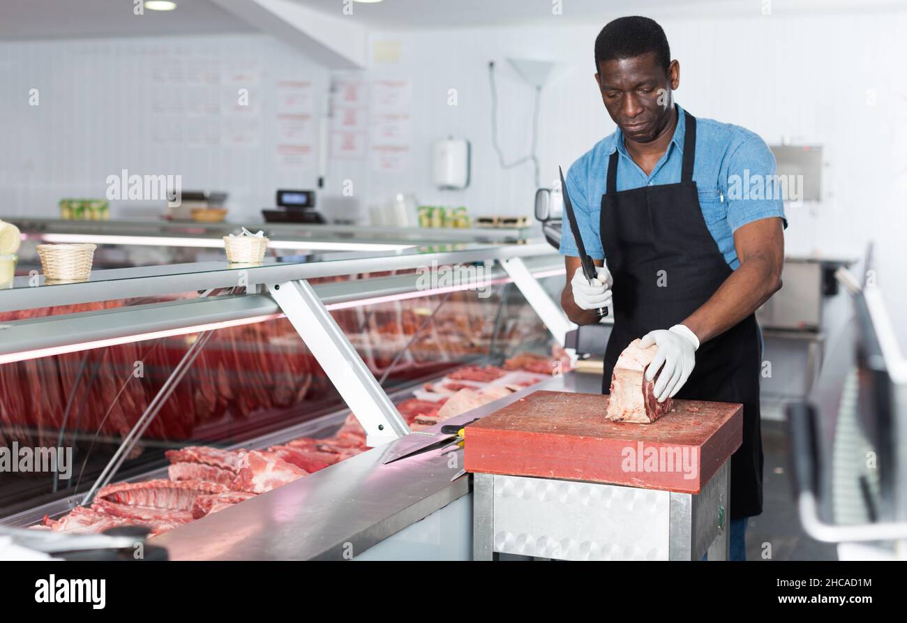 Butcher cutting meat Stock Photo - Alamy