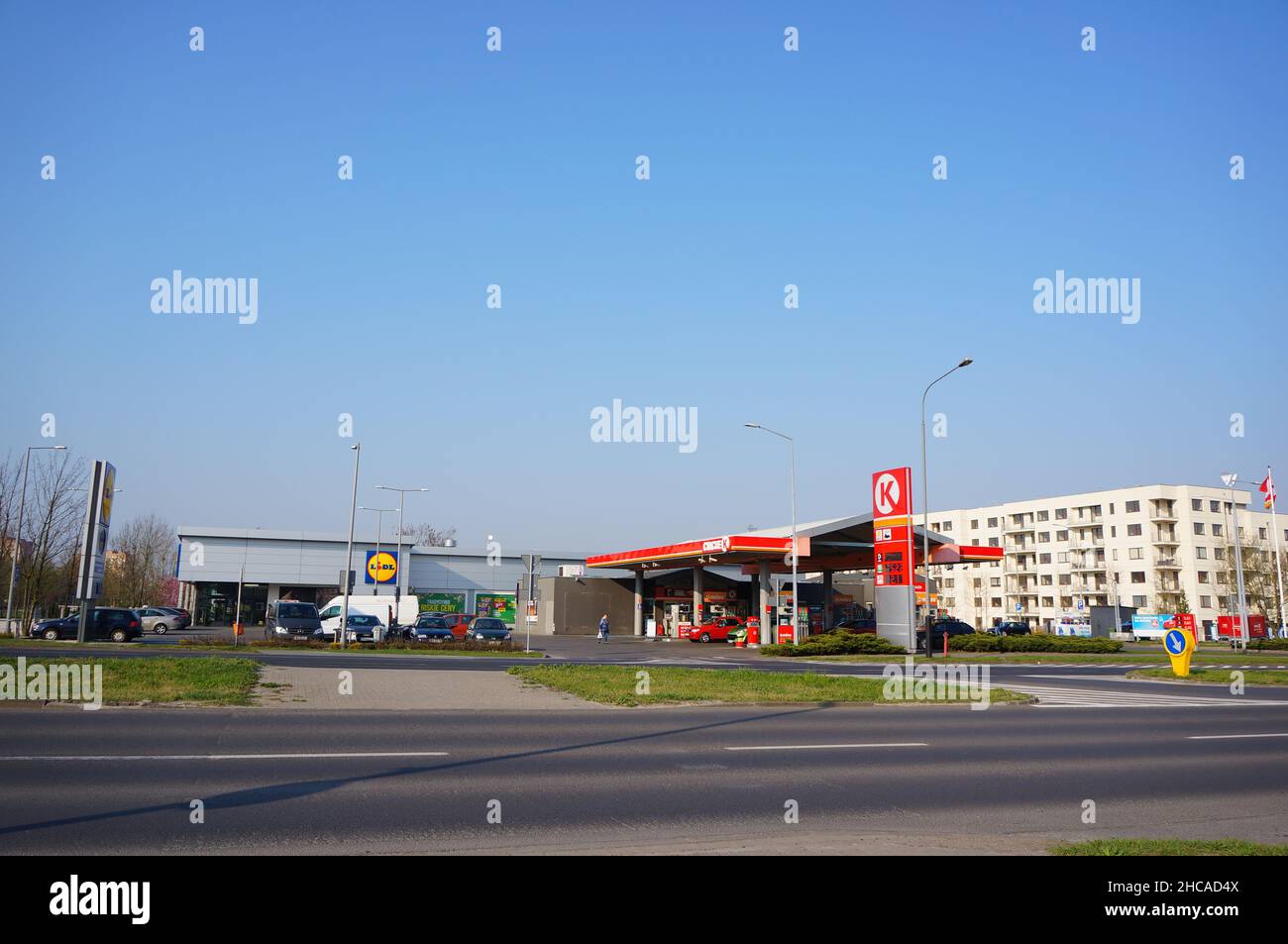 View of an asphalt road next to a Lidl supermarket and th gas station ...