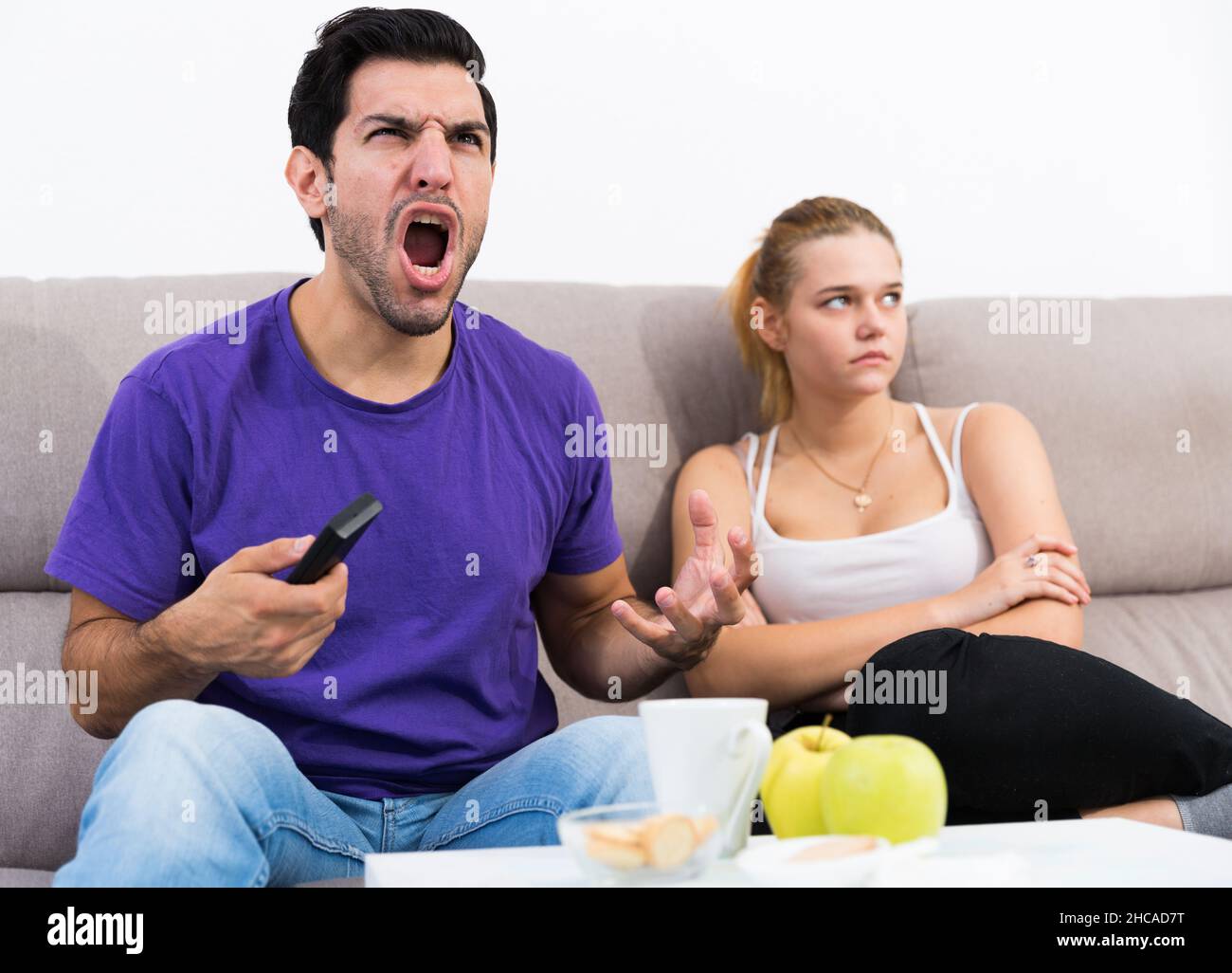 Man watching tv ignoring frustrated girl Stock Photo - Alamy
