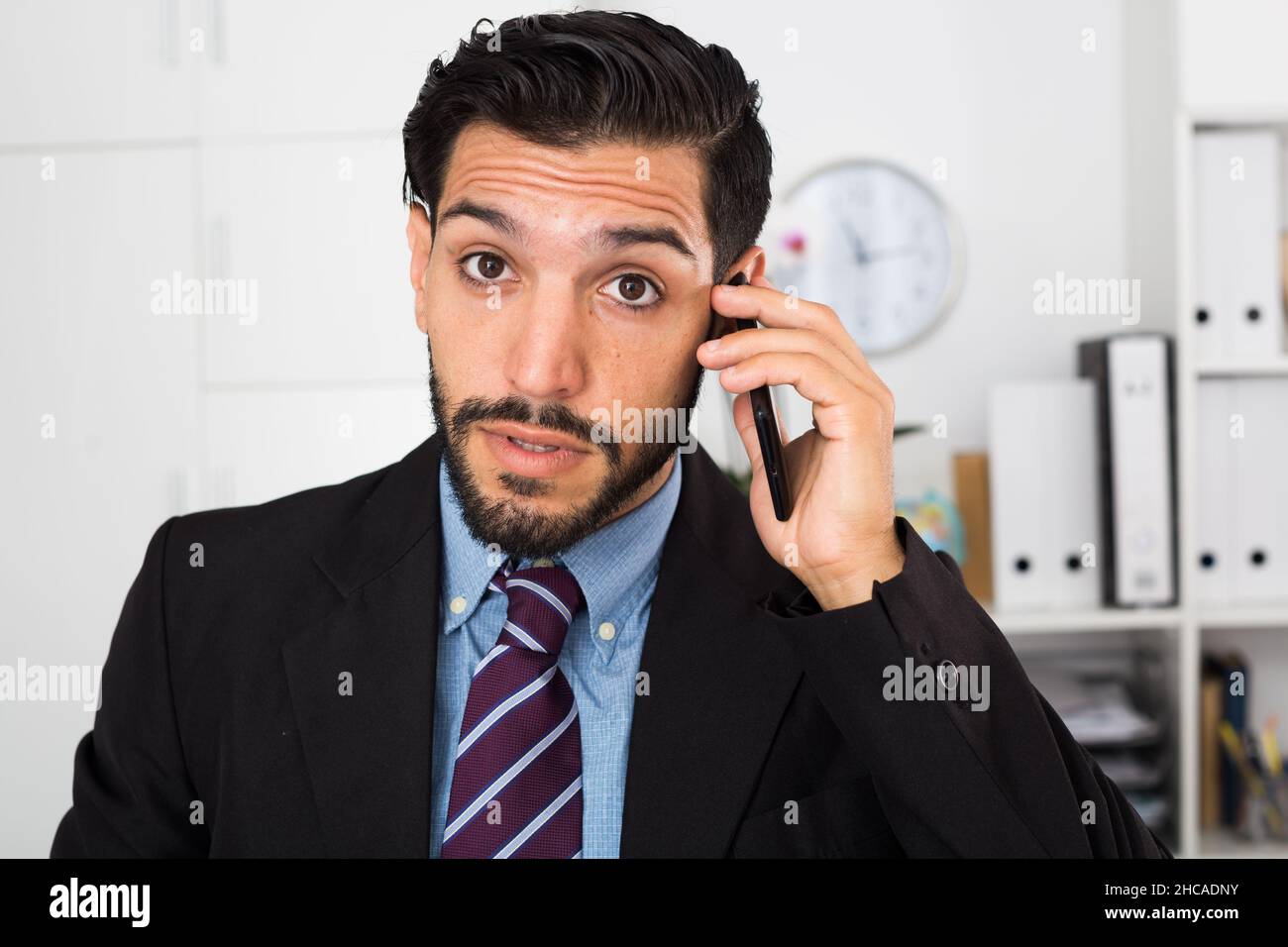 Surprised spanish businessman is talking phone with his partner Stock ...