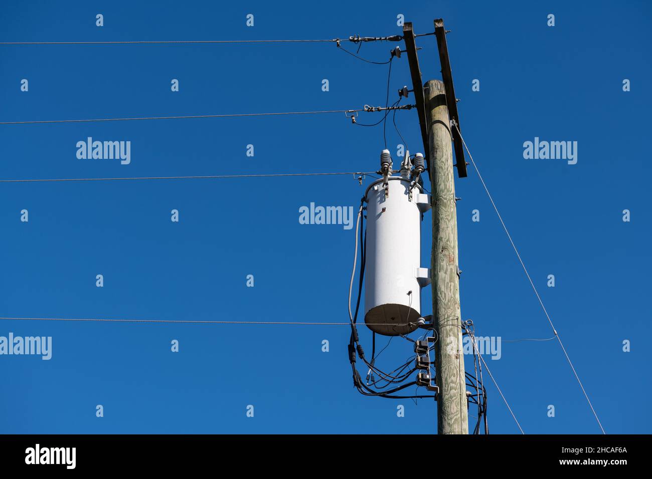 Transformer and high voltage power line towers shot from below on a ...