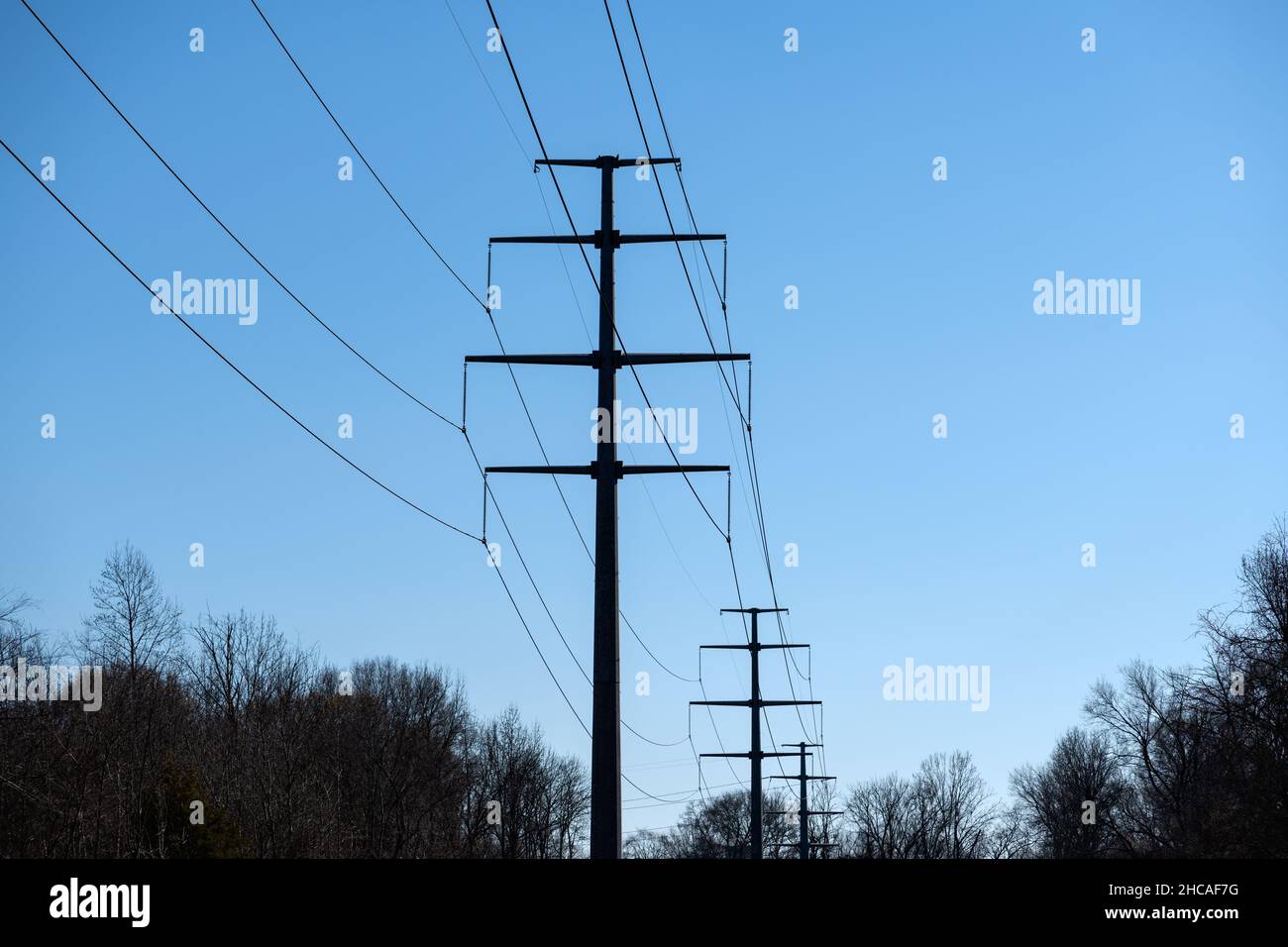 High voltage power line towers shot from below on a sunny day and blue ...