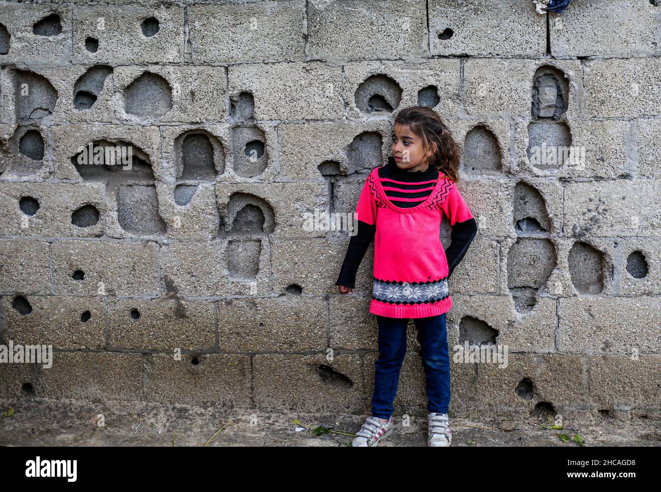 Gaza, Palestine. 26th Dec, 2021. A Palestinian girl stands in front of ...