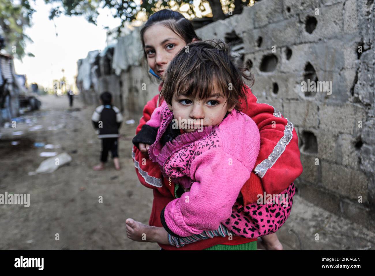 Palestinian children play in front of their house at a poor ...