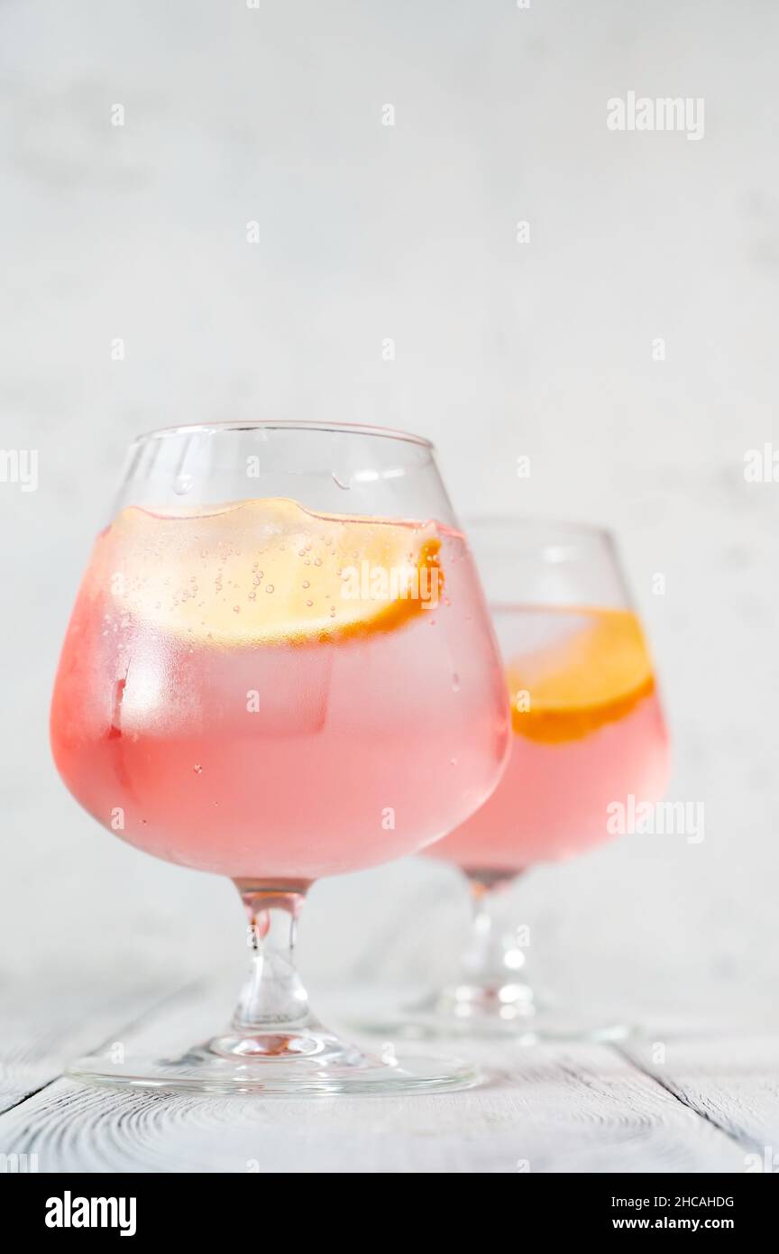 Pink vodka lemonade cocktail garnished with lemon wedge Stock Photo - Alamy
