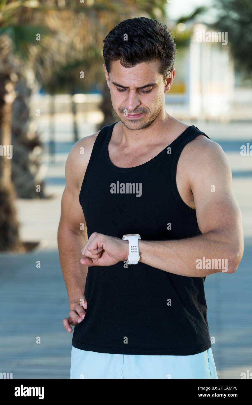 Athletic man looking at watch Stock Photo - Alamy