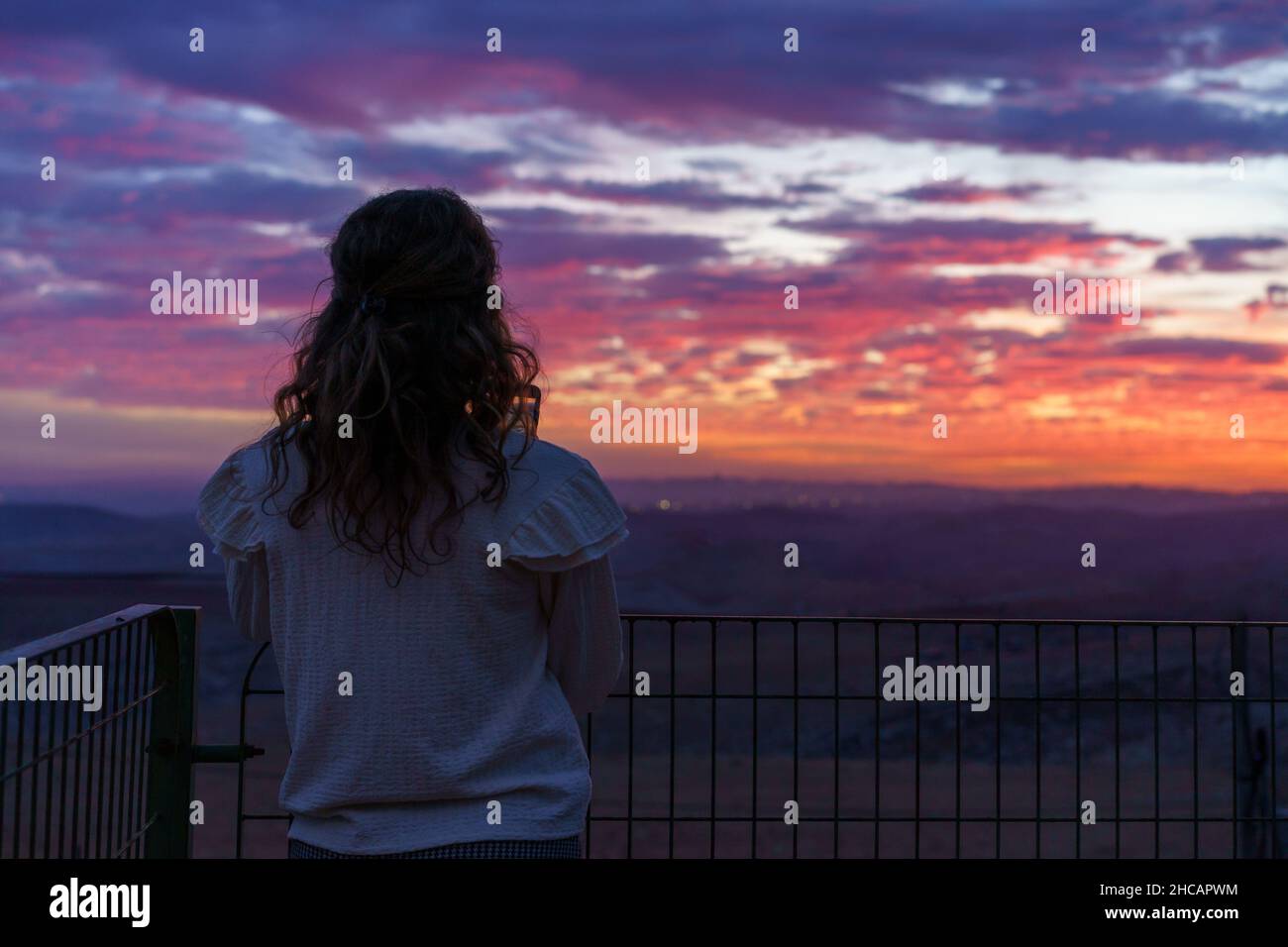 Back view beautiful young woman enjoying the amazing sunset Stock Photo ...