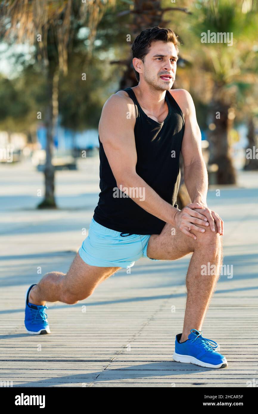 Male athlete stretching legs after strength training Stock Photo - Alamy