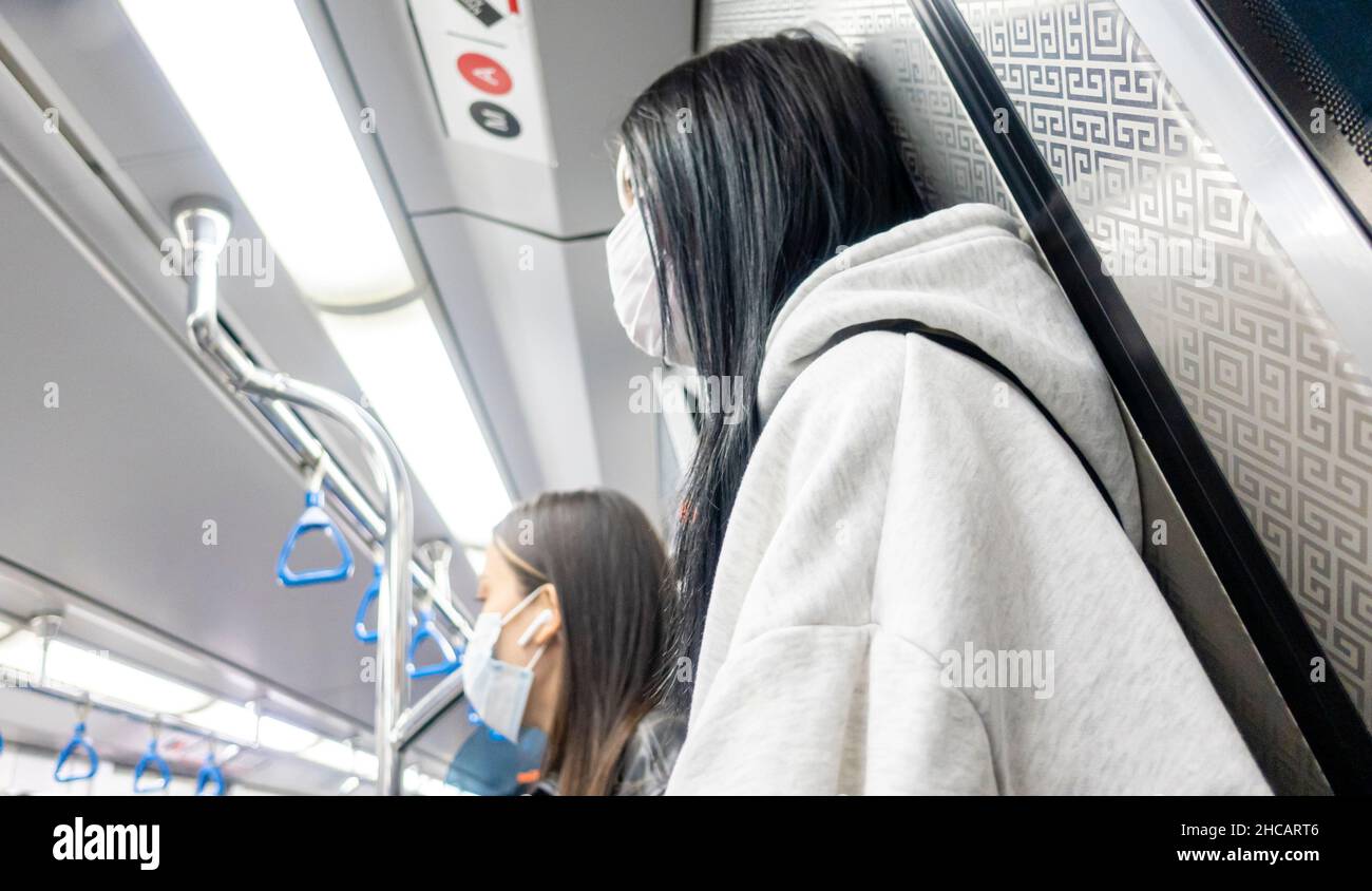 Female commuters in face mask masks riding a n Almaty metro subway ...