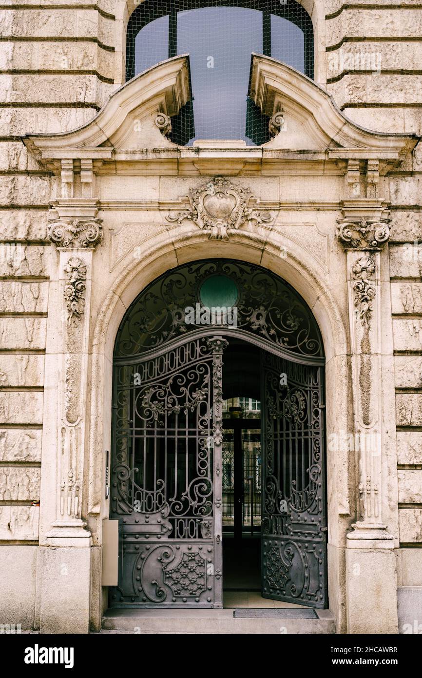 Facade of an old stone building with stucco and wrought iron gates ...