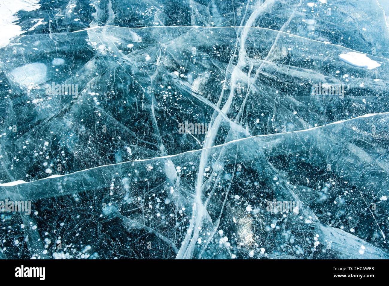 Texture of beautiful blue ice with cracks and air bubbles in the frozen ...
