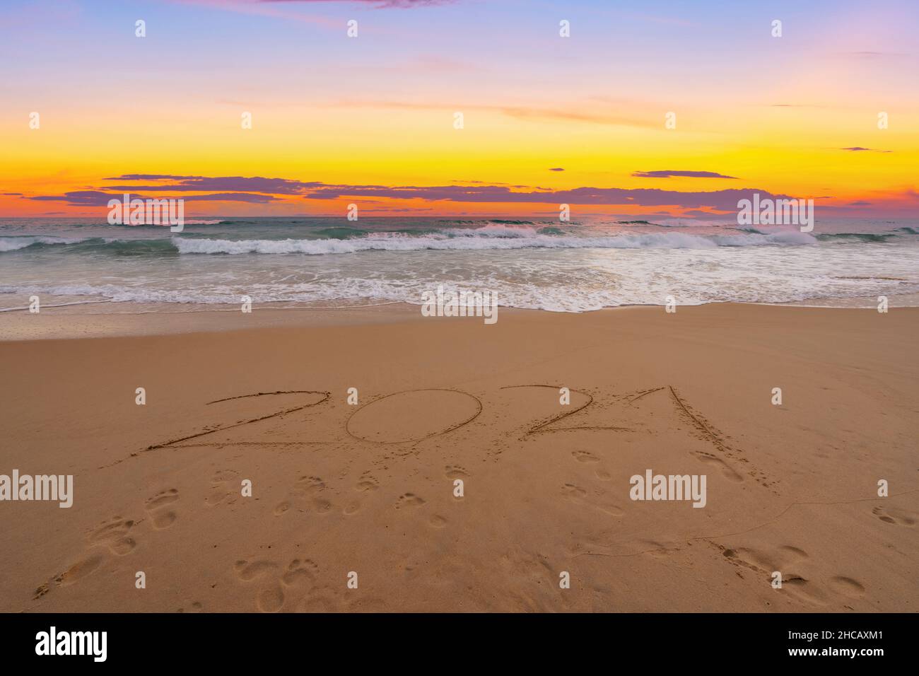 Text 2021 Lettering on the beach with waves and sunset sky Numbers 2021 ...