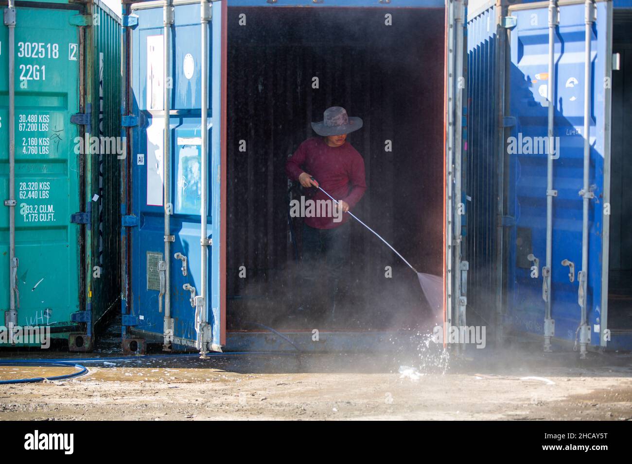 worker is cleaning container water spay gun Stock Photo - Alamy