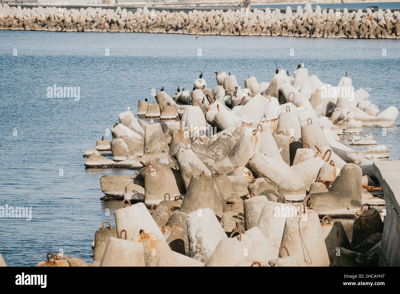 Coast breakwaters protecting from large waves with sea water background ...