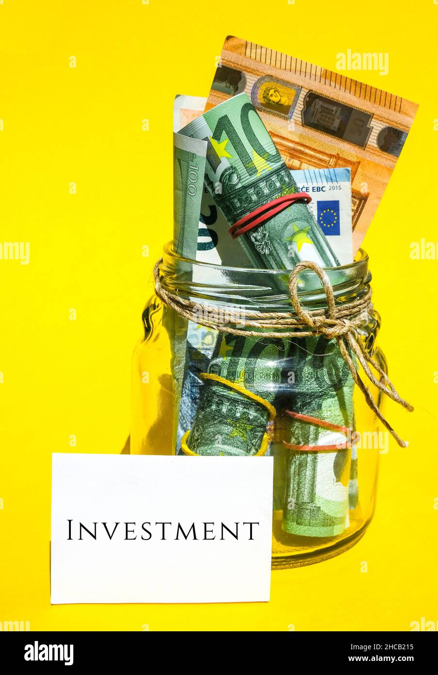 Euros money cash in rubber band, note text written INVESTMENT, concept ...
