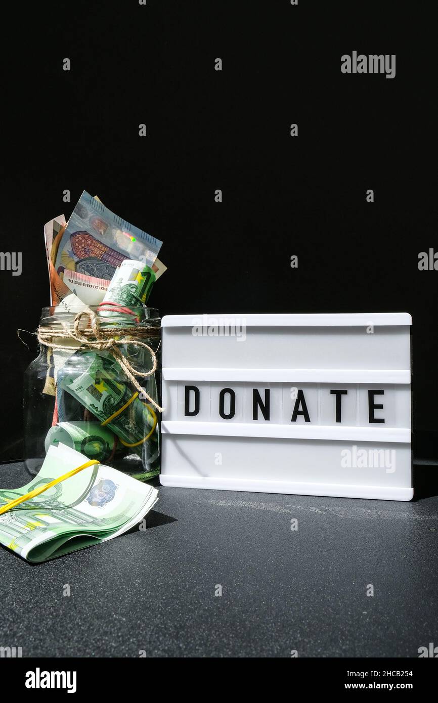 Lightbox board with word DONATE in black letters around Euro banknotes ...