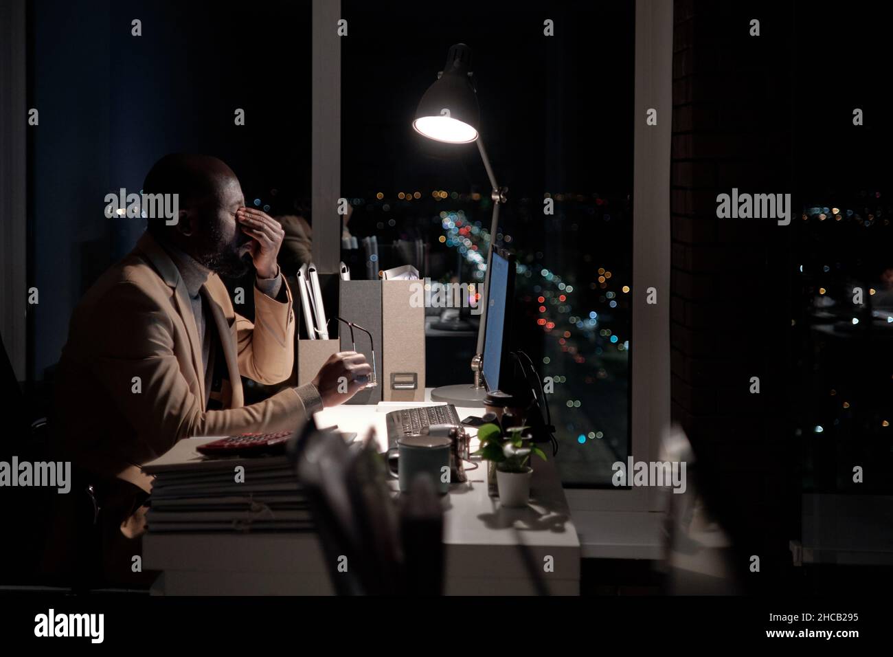 Young exhausted businessman trying to concentrate while working in ...