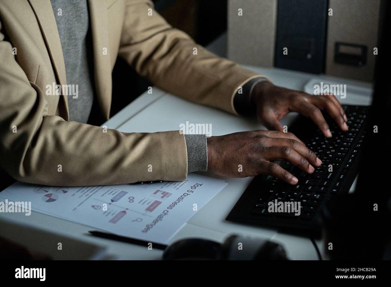 Hands of African businessman pressing keys of computer keypad while ...