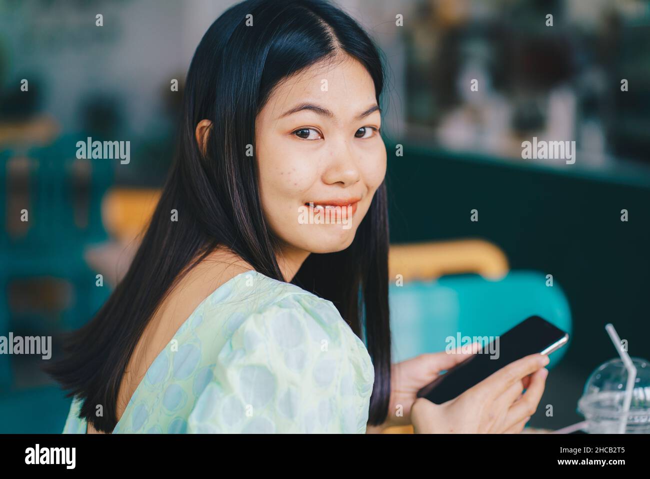 Mockup image of woman hand using black mobile phone with laptop screen ...