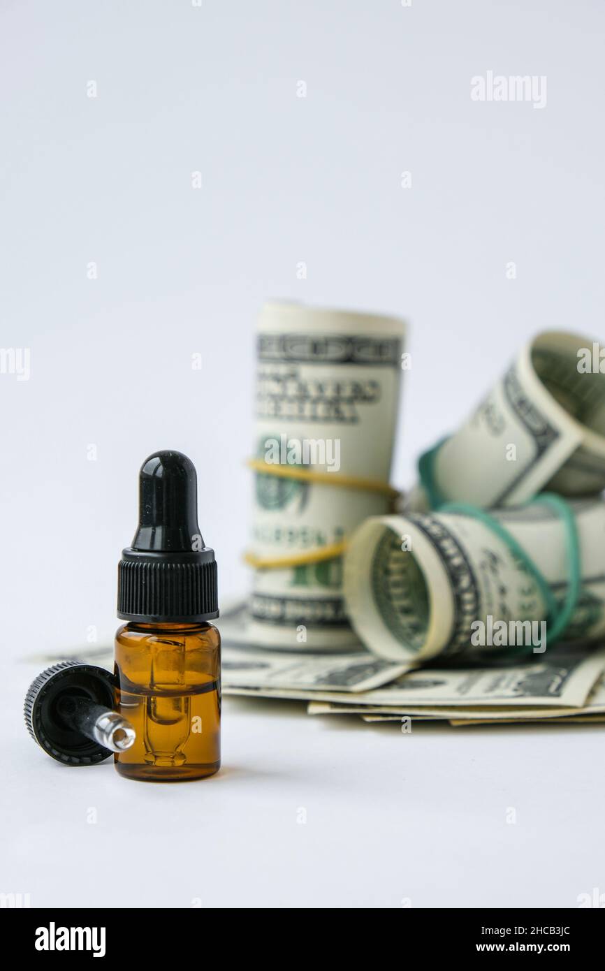 Stack of cash dollars and pipette medicine. The concept of medical ...