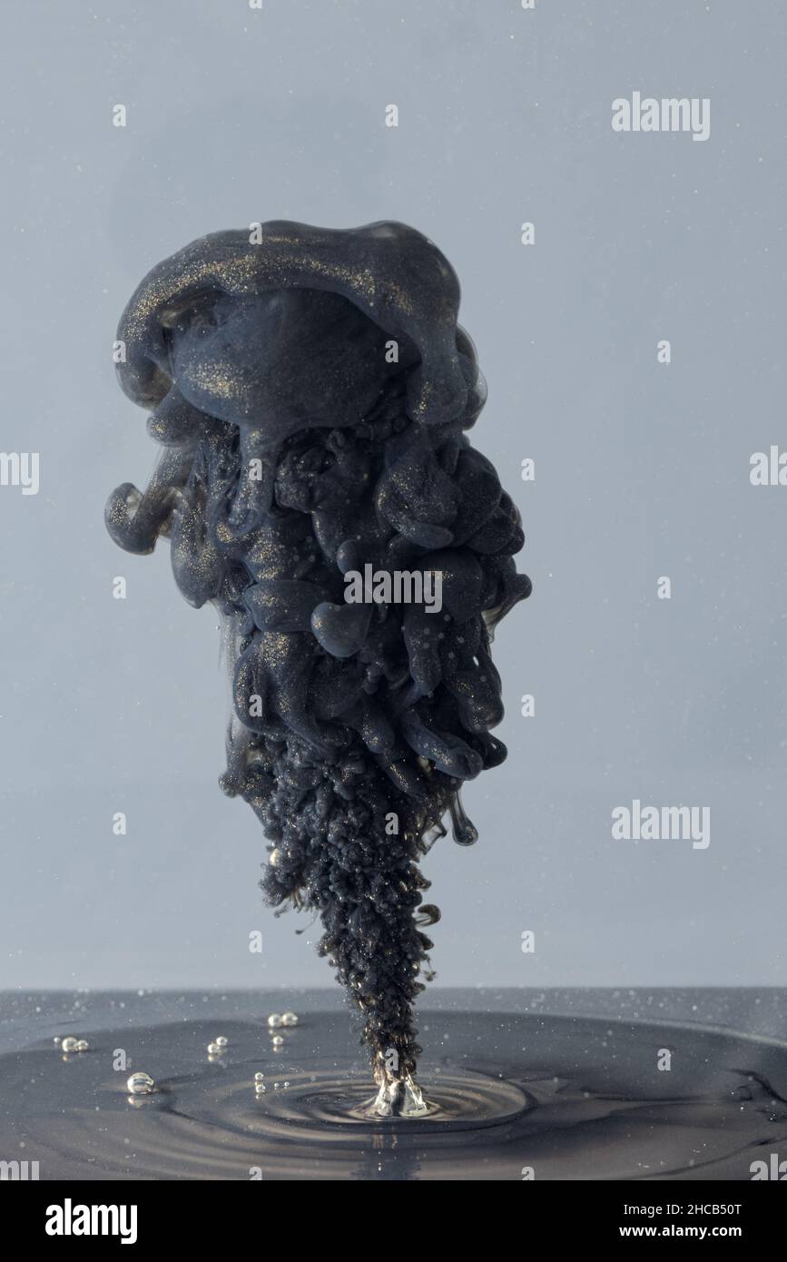 Explosion of colored, fluid and neoned liquids on black studio ...