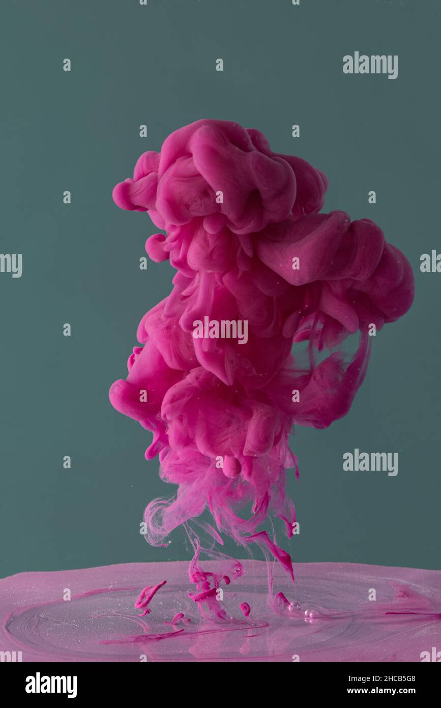 Explosion of colored fluid, ink, dye and neoned liquid on blue-gray ...