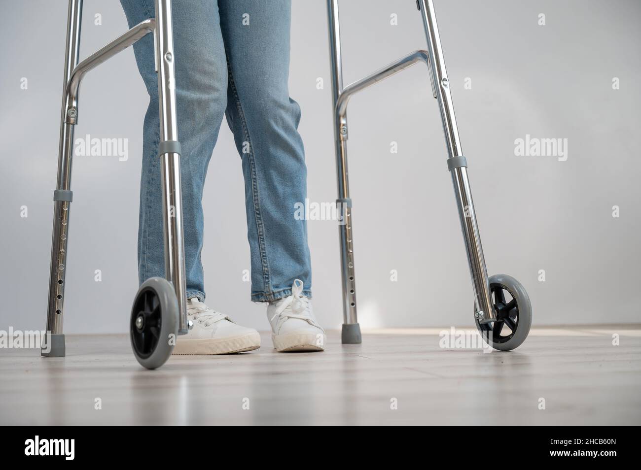 Close-up of female legs with walkers. The girl walks with the help of ...