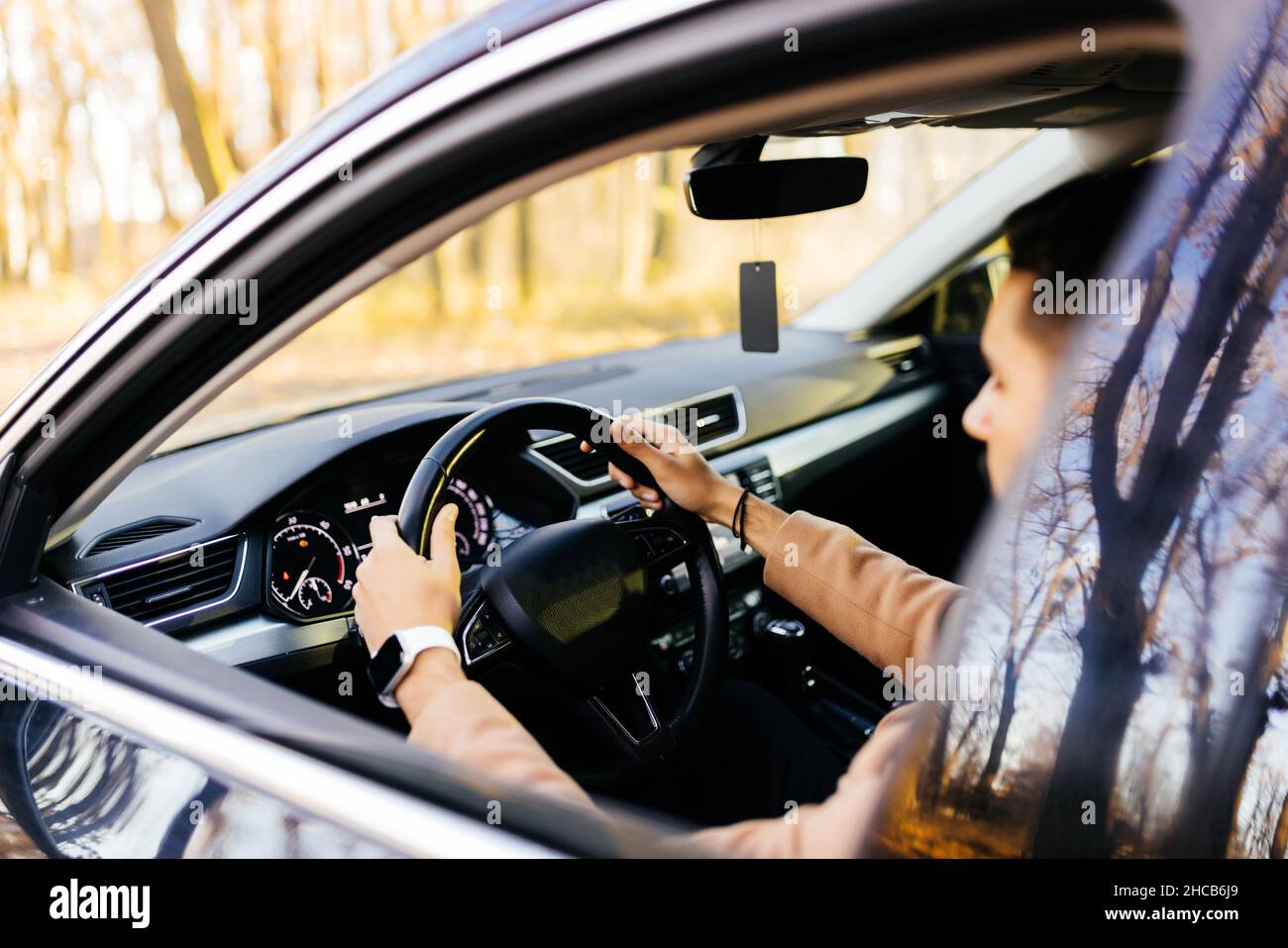 Happy owner. Handsome man sitting relaxed in his newly bought car ...