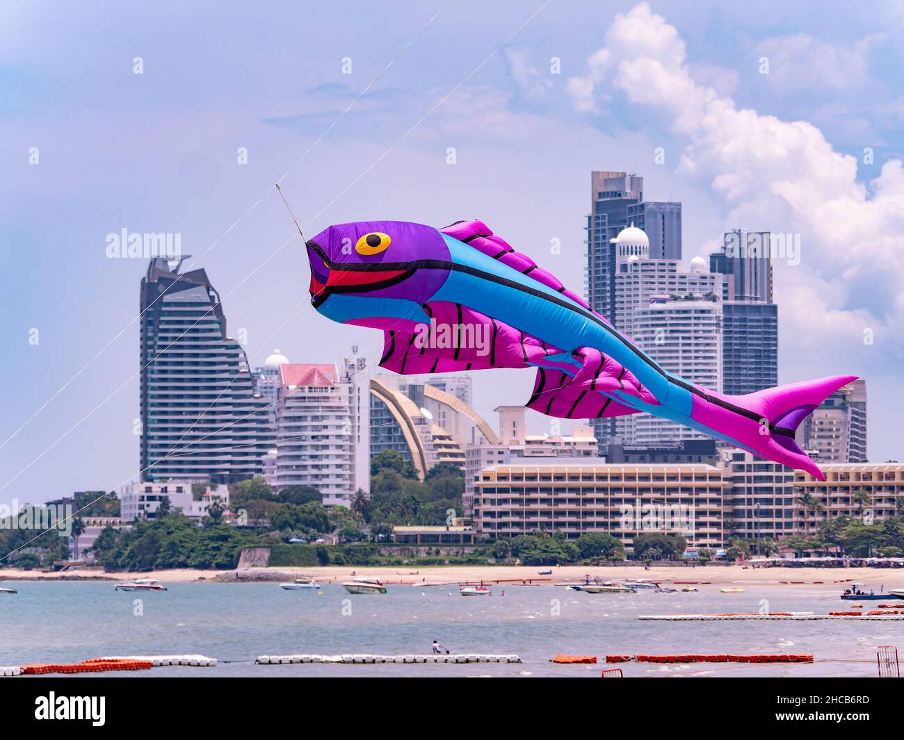 Fish shaped kite at the beach in Pattaya, Thailand. High-rise hotels in ...