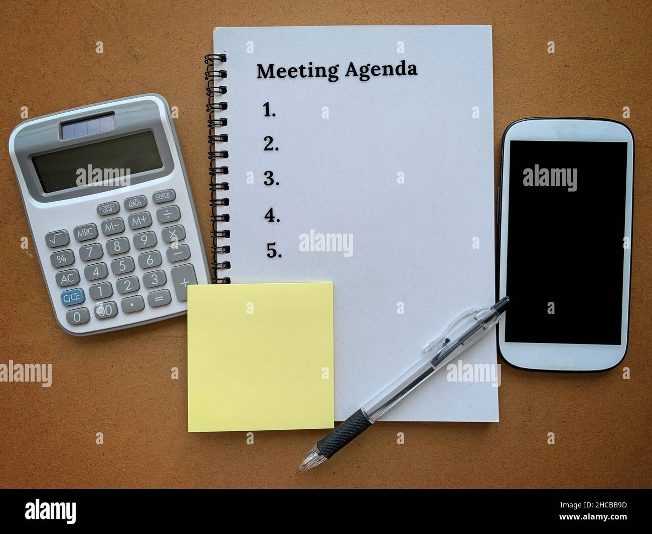 Meeting agenda text on notepad with stationery and smart phone ...