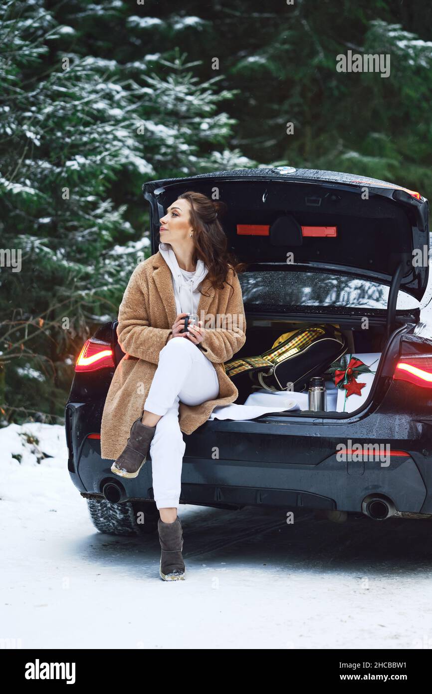 Tired driver woman stopped her car in winter forest road to give ...