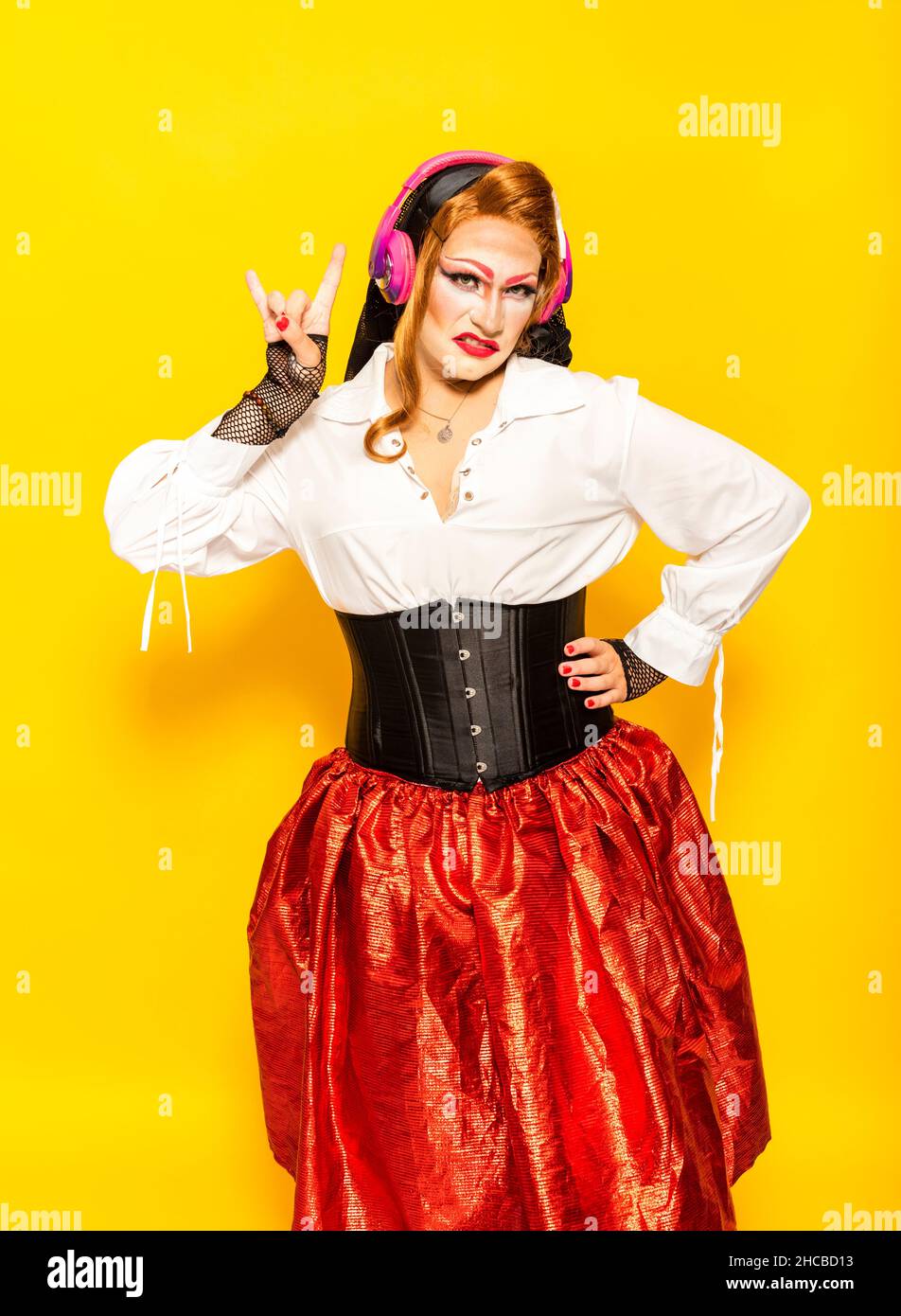 Drag Queen wearing headphones and eyeglasses in front of yellow ...