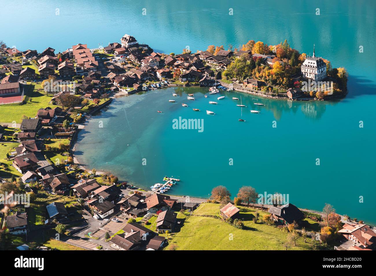 Boats by island on water at Iseltwald, Interlaken, Switzerland Stock ...