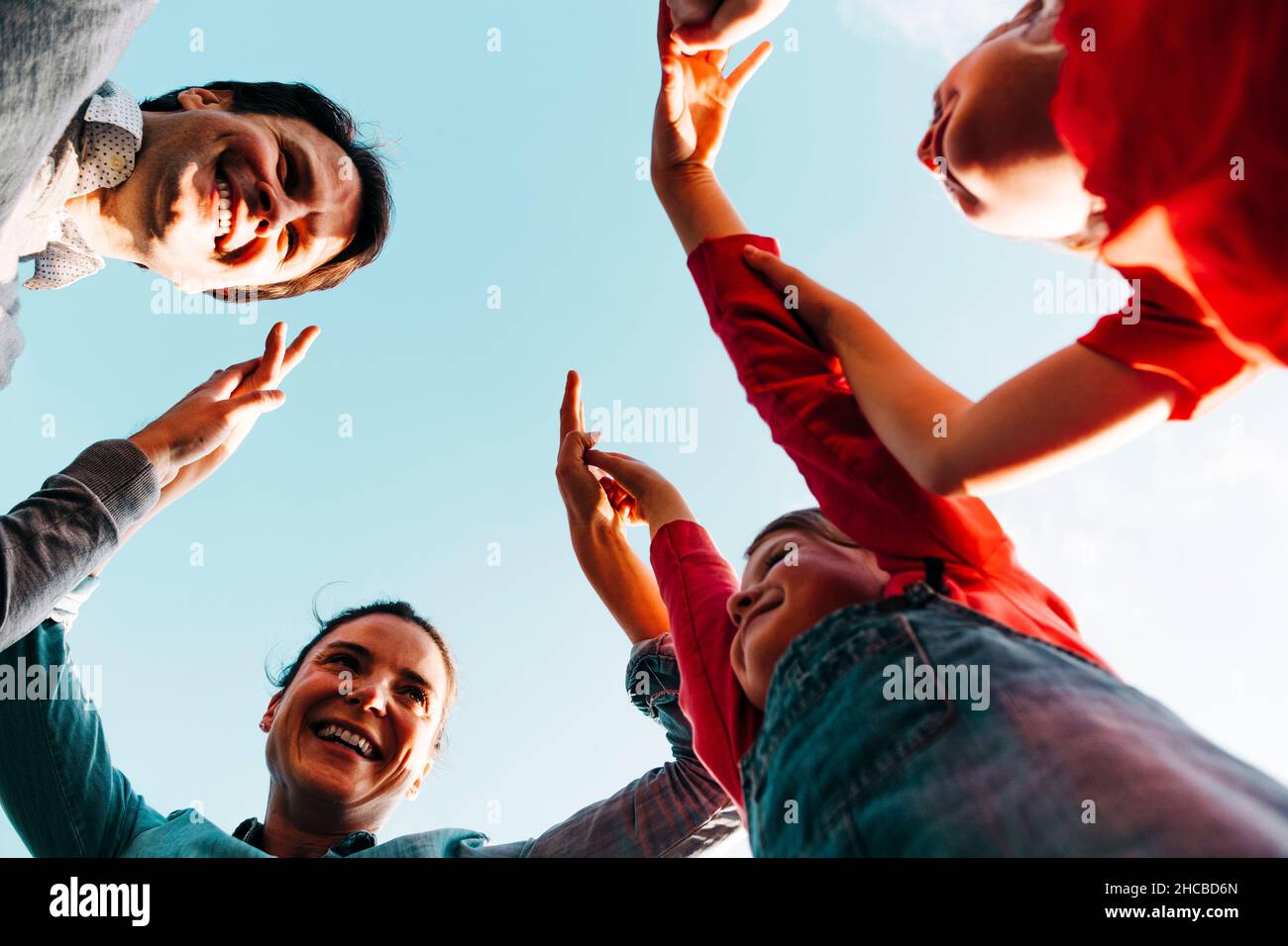 Happy mother and father doing high-five with daughters Stock Photo - Alamy