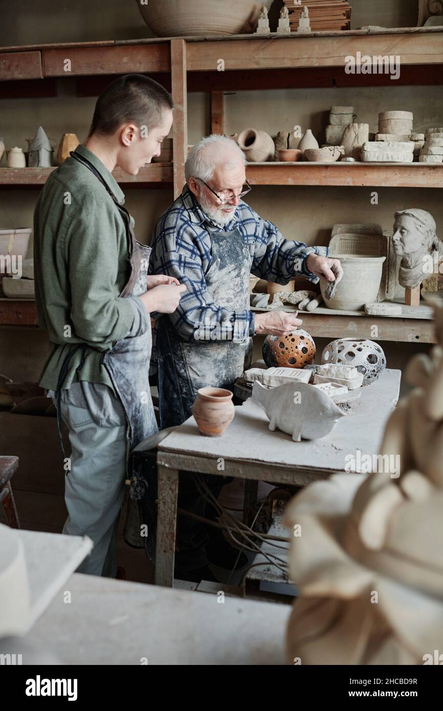 People working making sculptures from clay in team during their work in ...