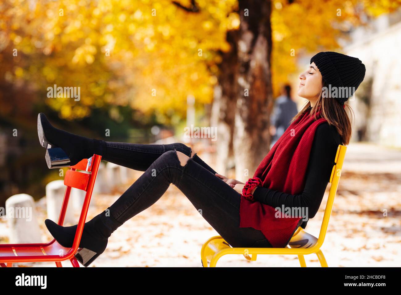Teenage girl in scarf napping on chair at public park Stock Photo - Alamy
