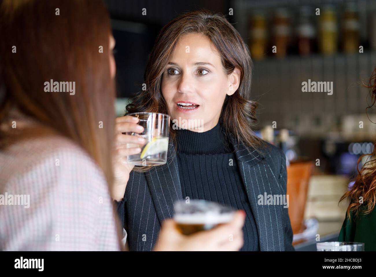 Smiling businesswomen having drinks in pub Stock Photo - Alamy