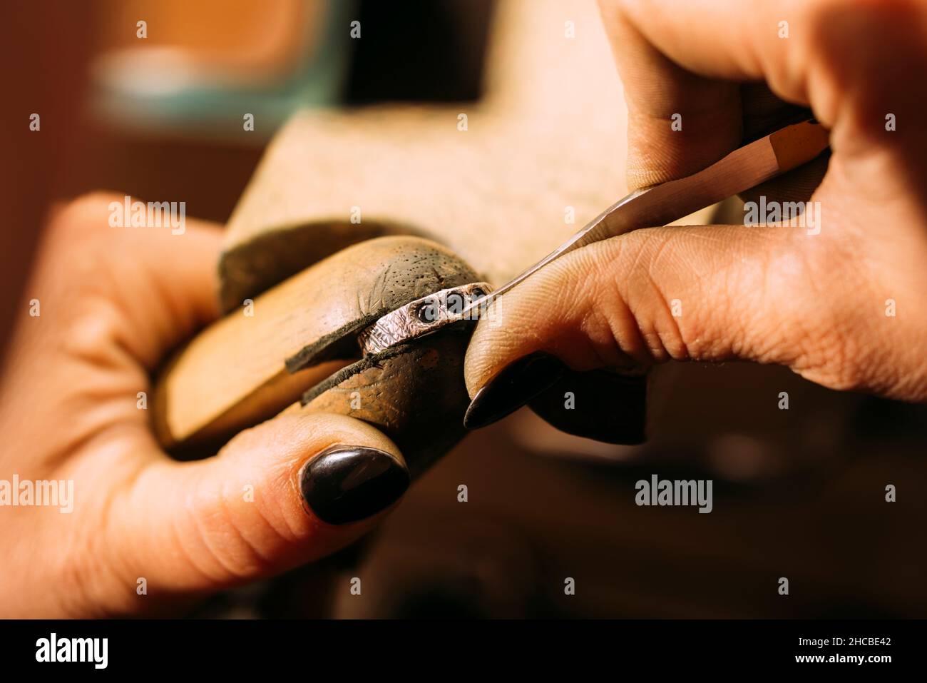 Female jeweler positioning diamond in ring at workshop Stock Photo - Alamy