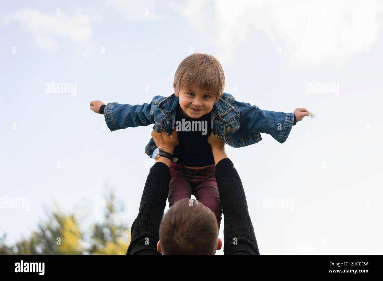 Man holding son aloft with arms outstretched Stock Photo - Alamy