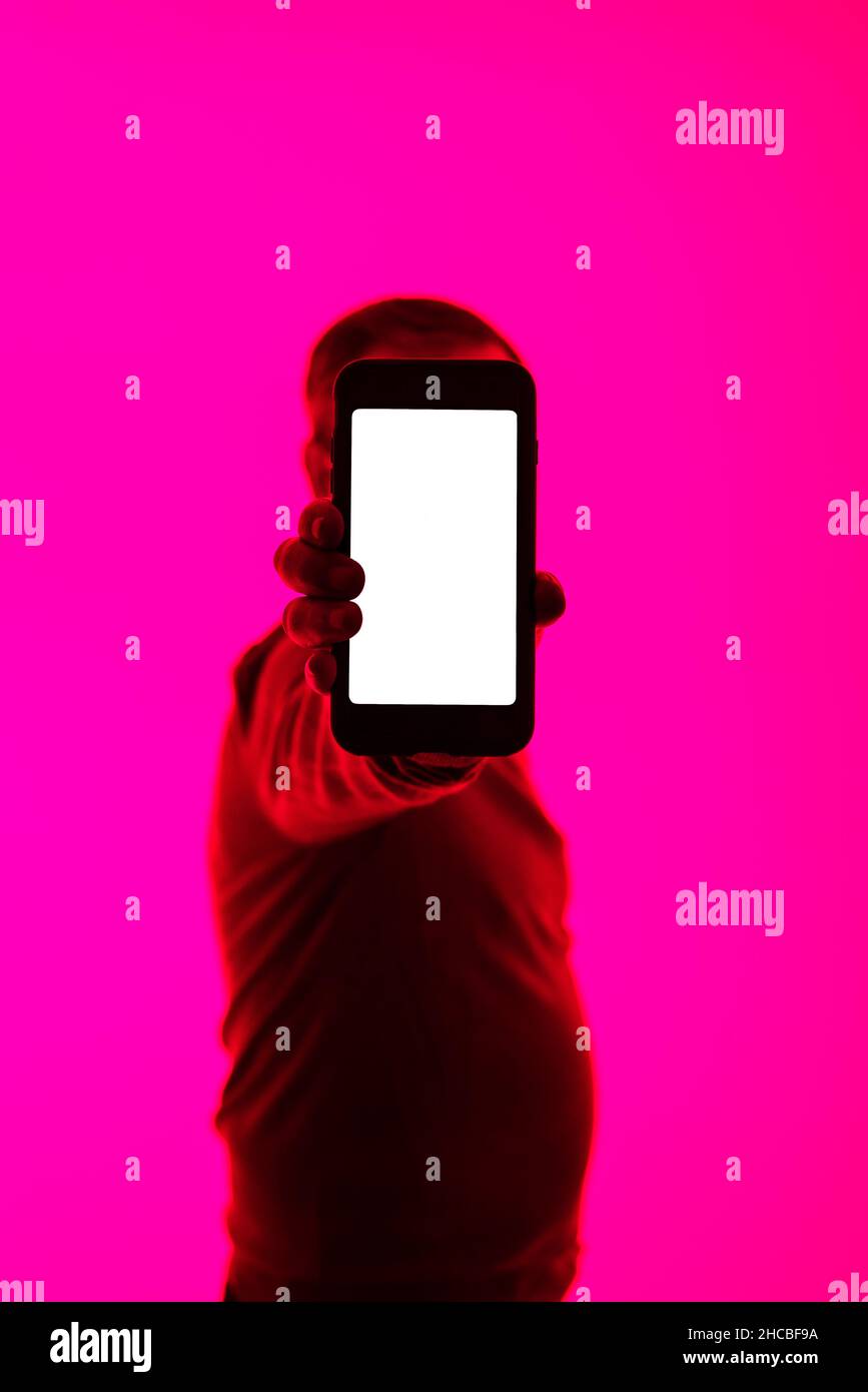 Shocked man on tiptoe looking at mobile phone by pink background Stock ...