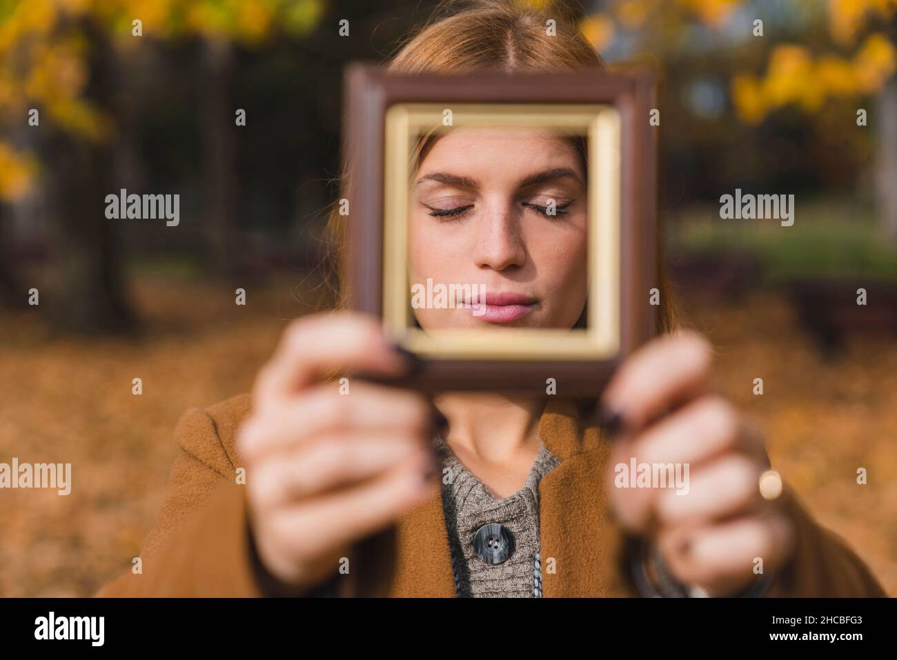 Woman with eyes closed seen through photo frame Stock Photo - Alamy
