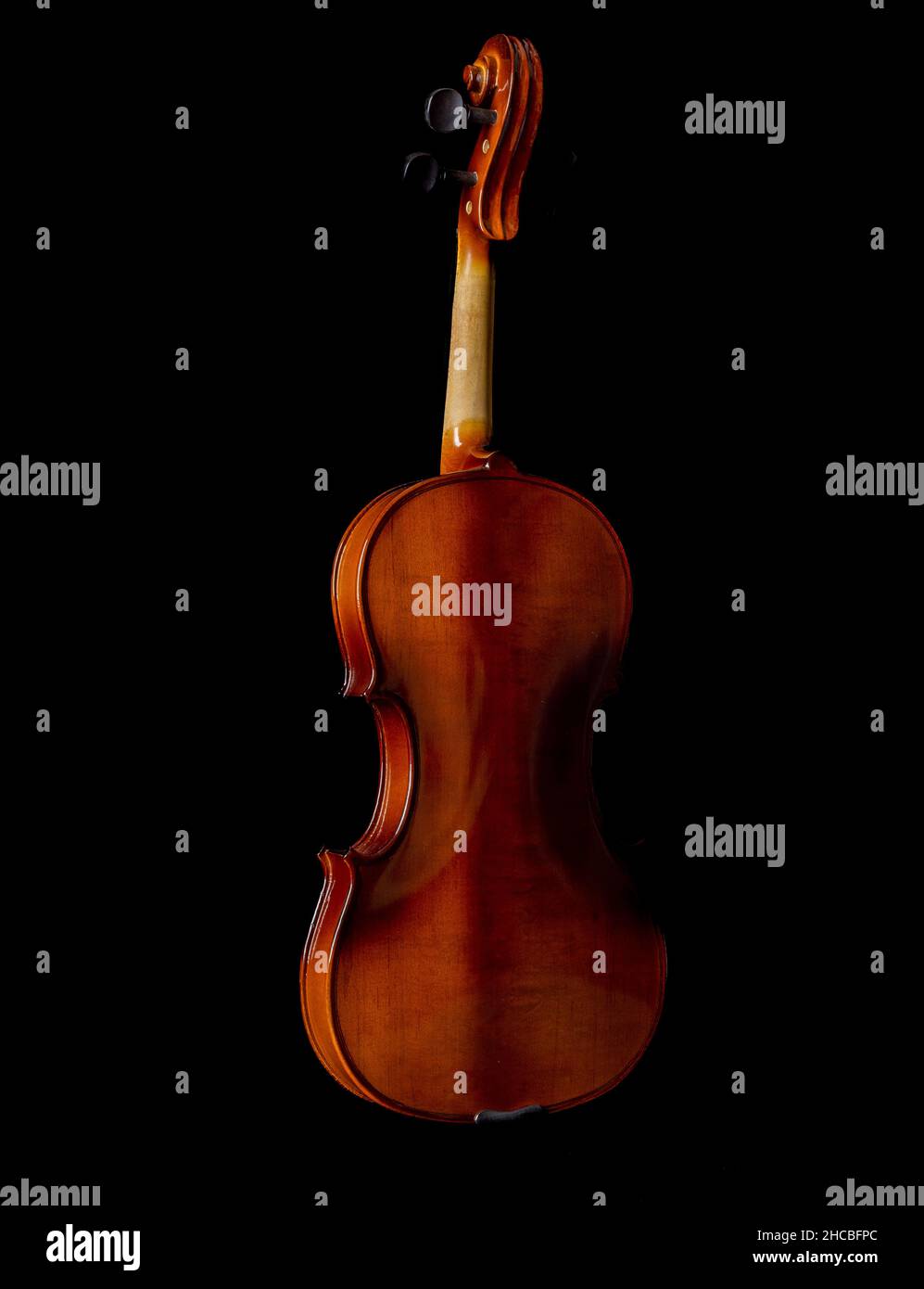 Light and shadow on the back of the violin isolated on a black ...