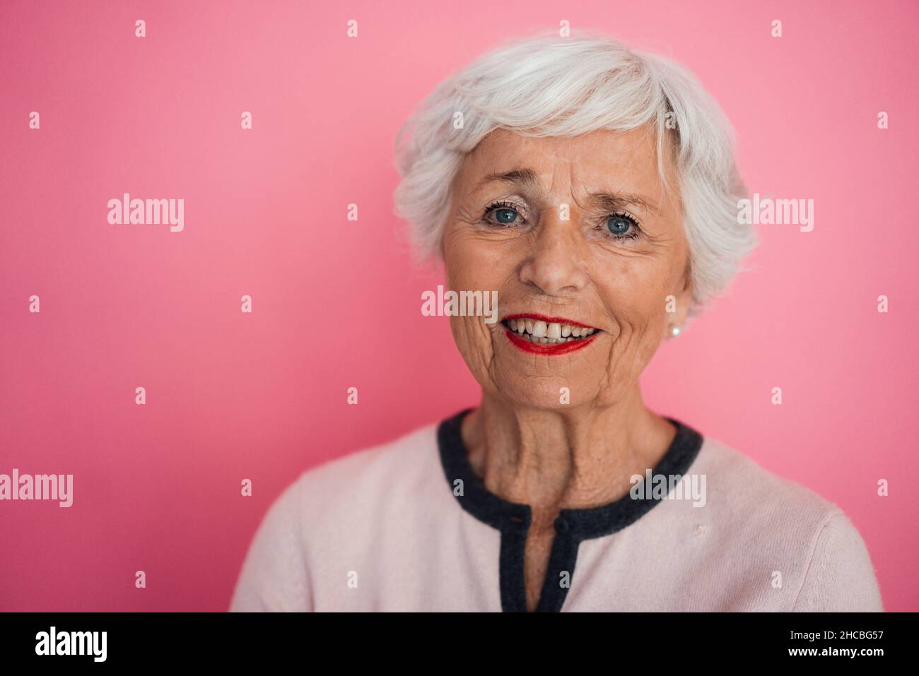 Happy senior woman against pink background Stock Photo - Alamy